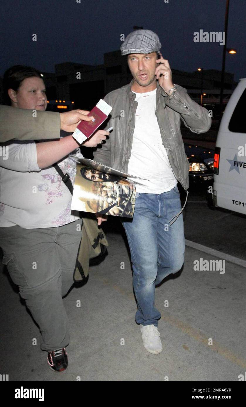 Gerard Butler wears a stylish houndstooth patterned golf hat as he ...