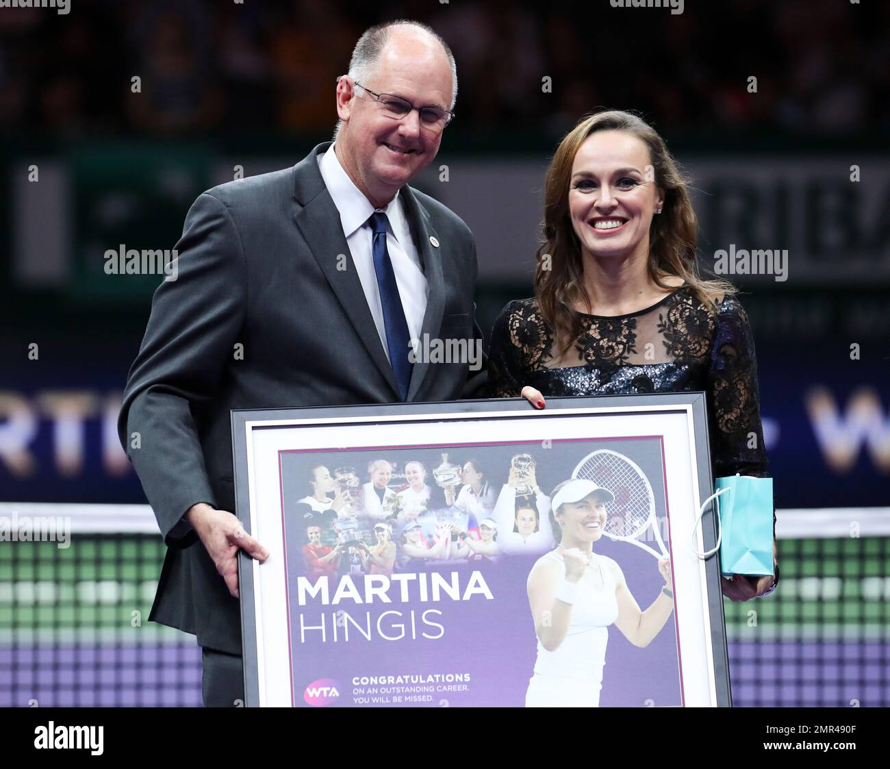 Martina Hingis of Switzerland, is presented with a gift by WTA Chief ...