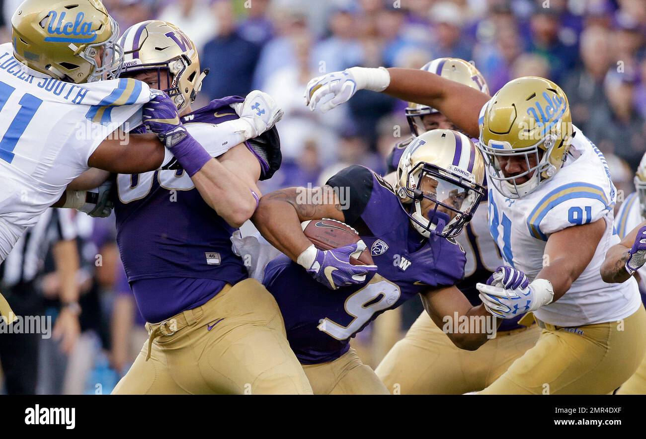 Washington's Myles Gaskin (9) tries to get past UCLA's Jacob Tuioti ...