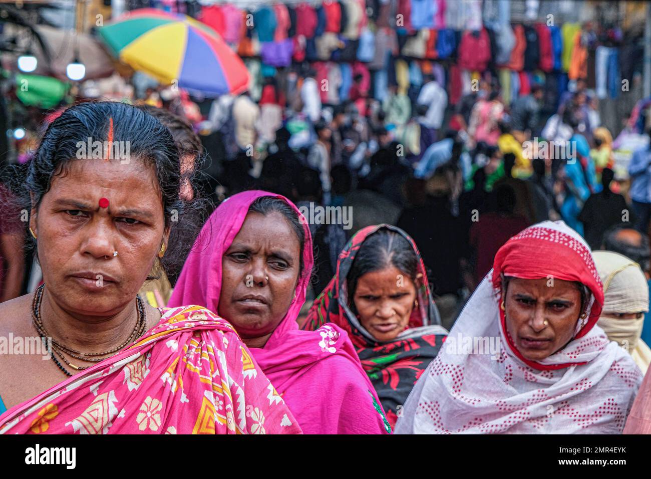 Women of different religions are crossing busy streets in a market area ...