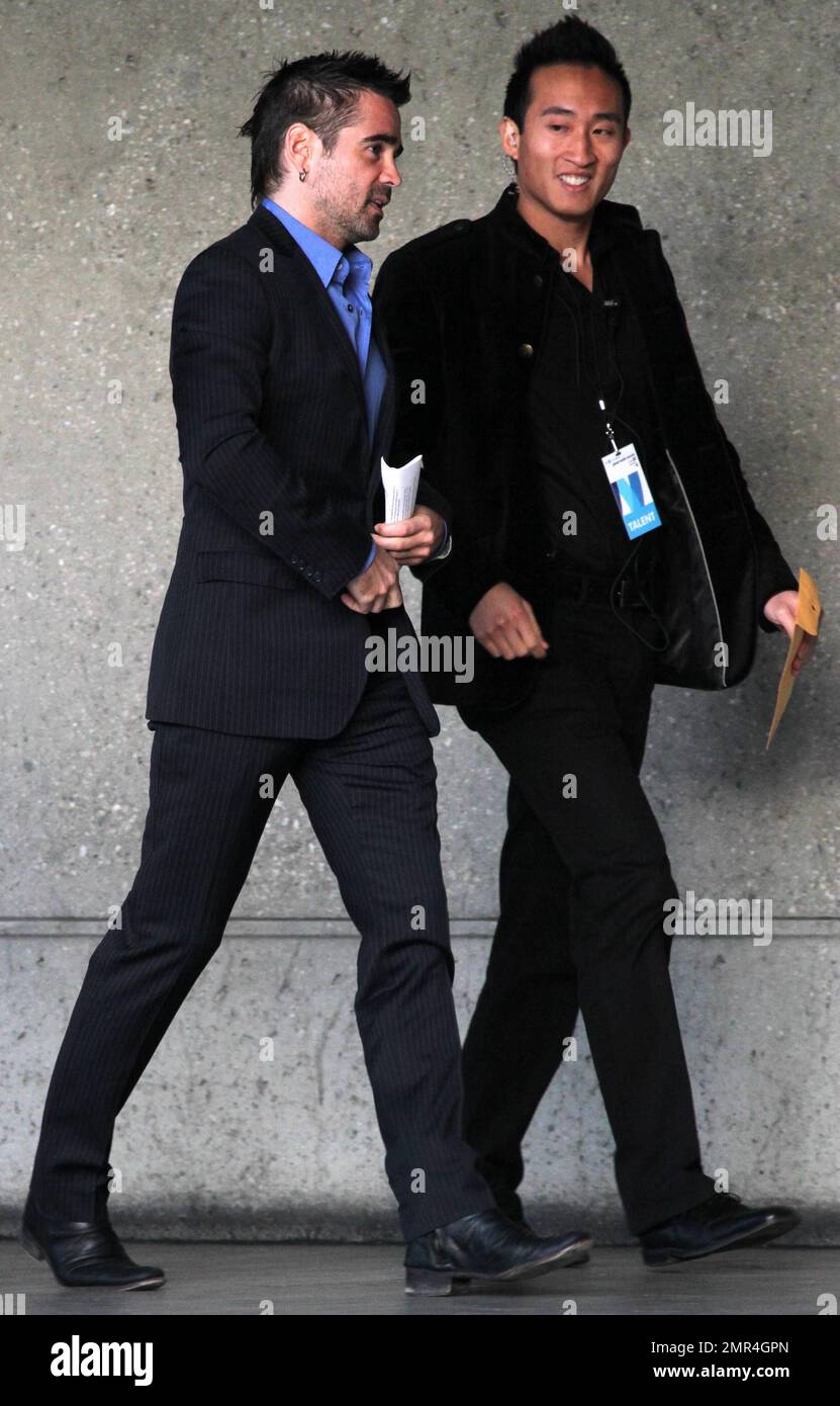 Colin Farrell buttons up his jacket on a snazzy suit and carries papers ...