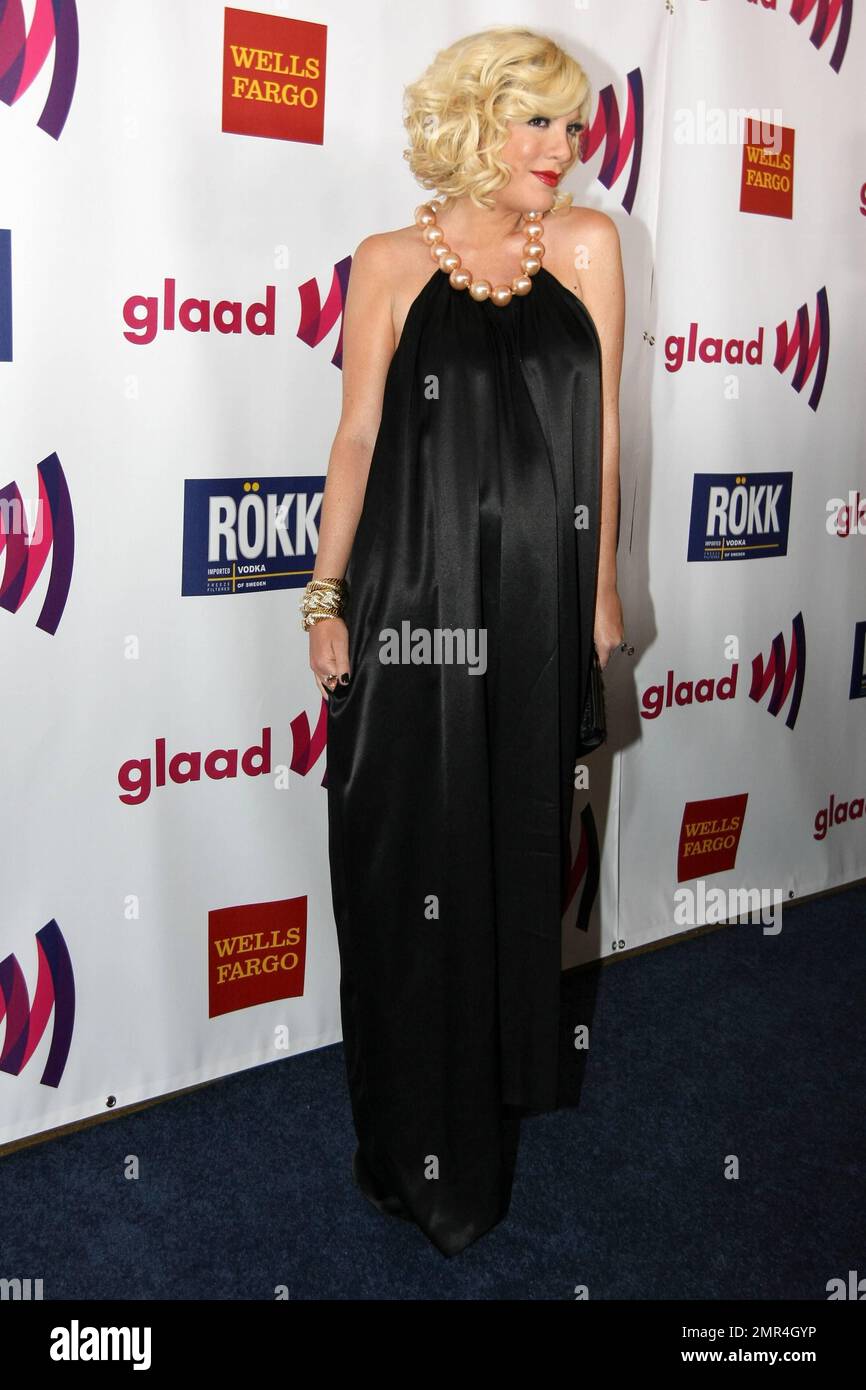 In a long black satin halter gown Tori Spelling appears to hide a baby ...