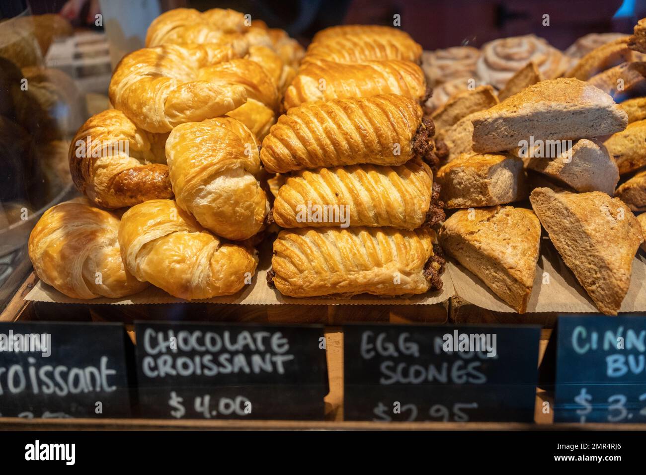 A closeup shot of baked sweets on display in a bakery, with their names ...