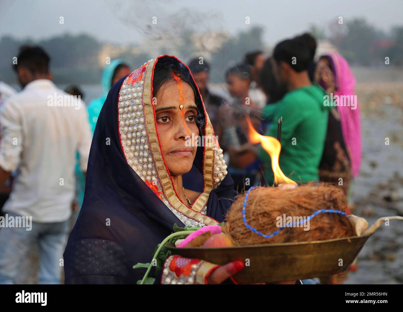 Hindu devotees perform rituals at sunset on the banks of the Tawi River ...