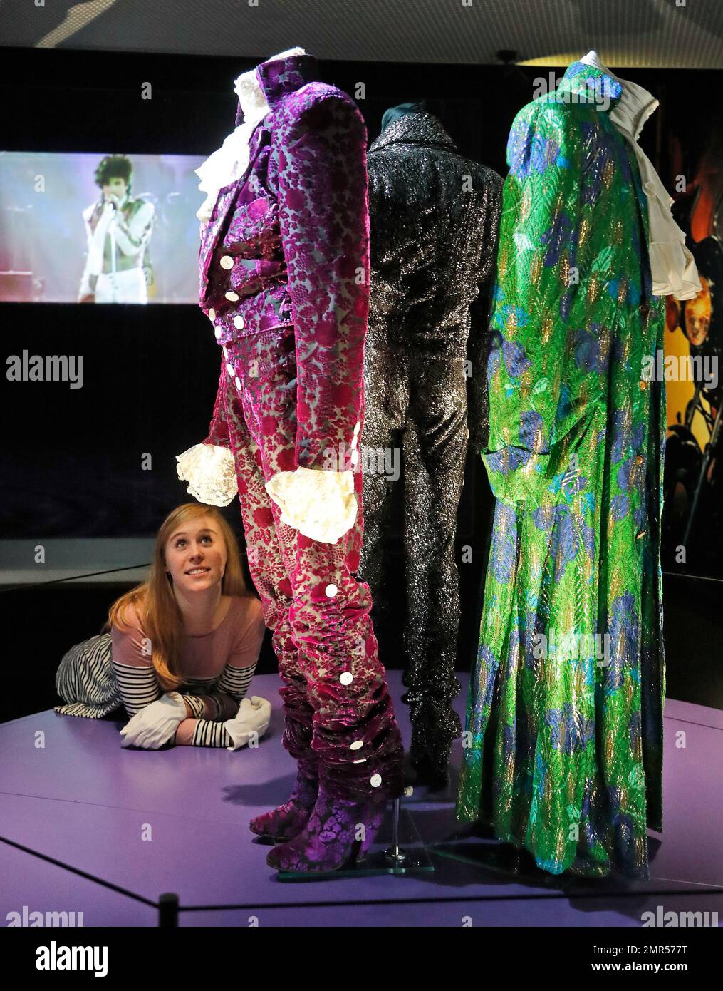 An employee looks at costumes once worn by artist Prince, at the 'My ...