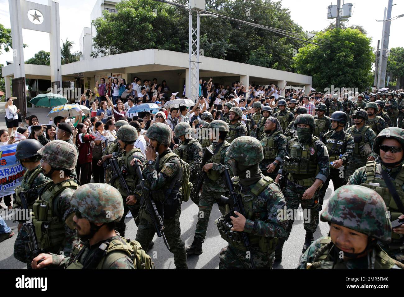 Residents and office workers wave at members of the Philippine National ...