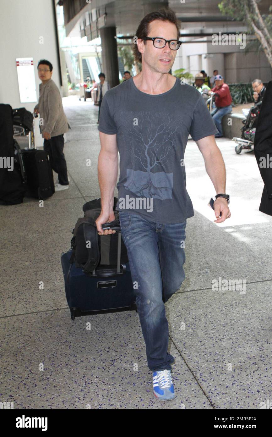 UK-born Australian actor Guy Pearce pulls along his luggage after ...