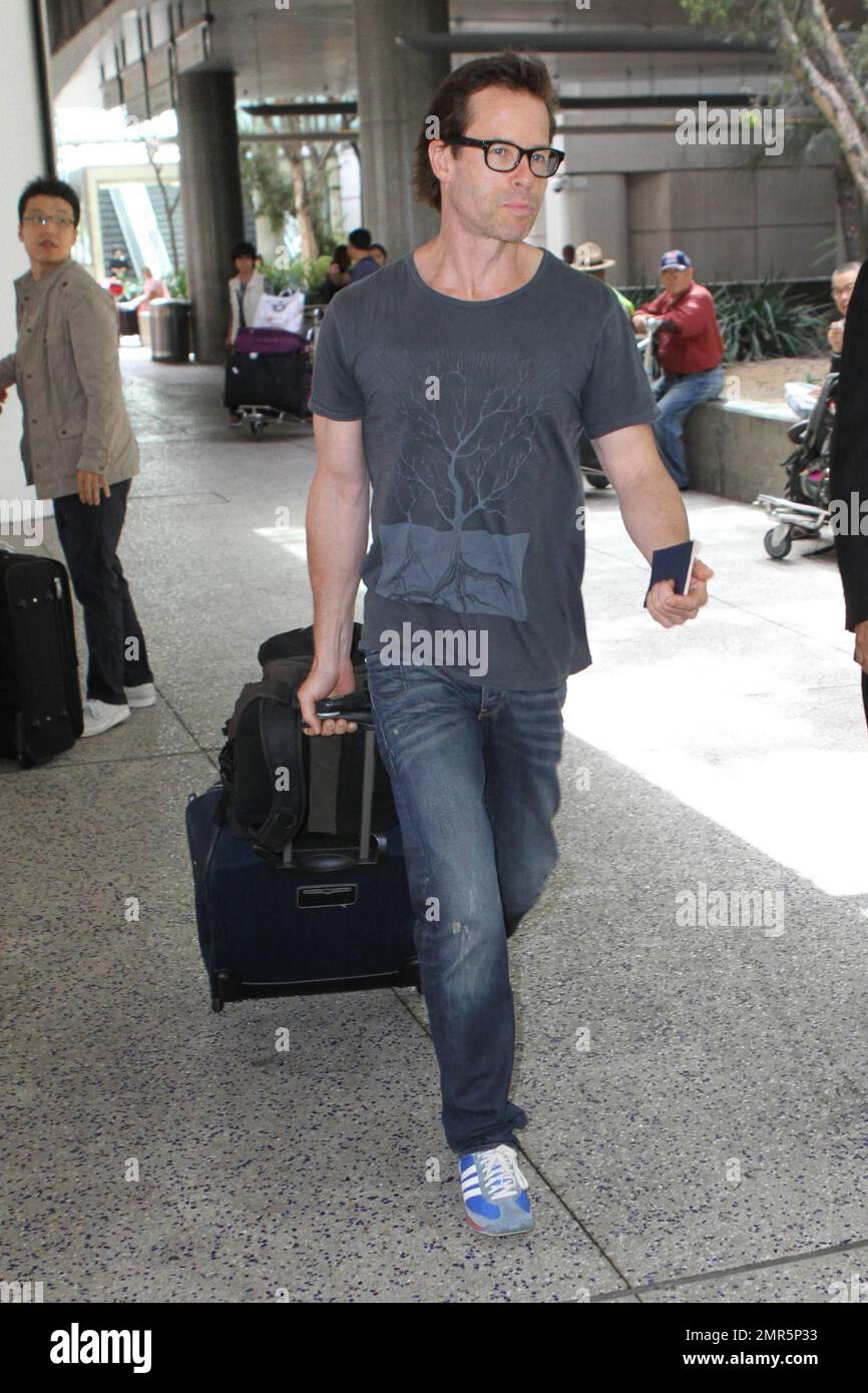 UK-born Australian actor Guy Pearce pulls along his luggage after ...