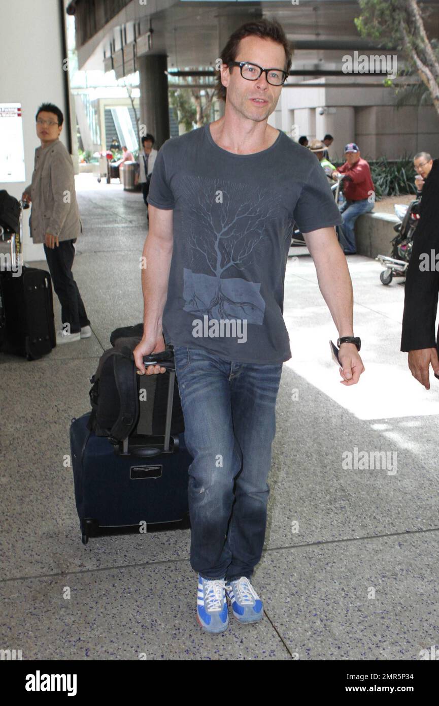 UK-born Australian actor Guy Pearce pulls along his luggage after ...