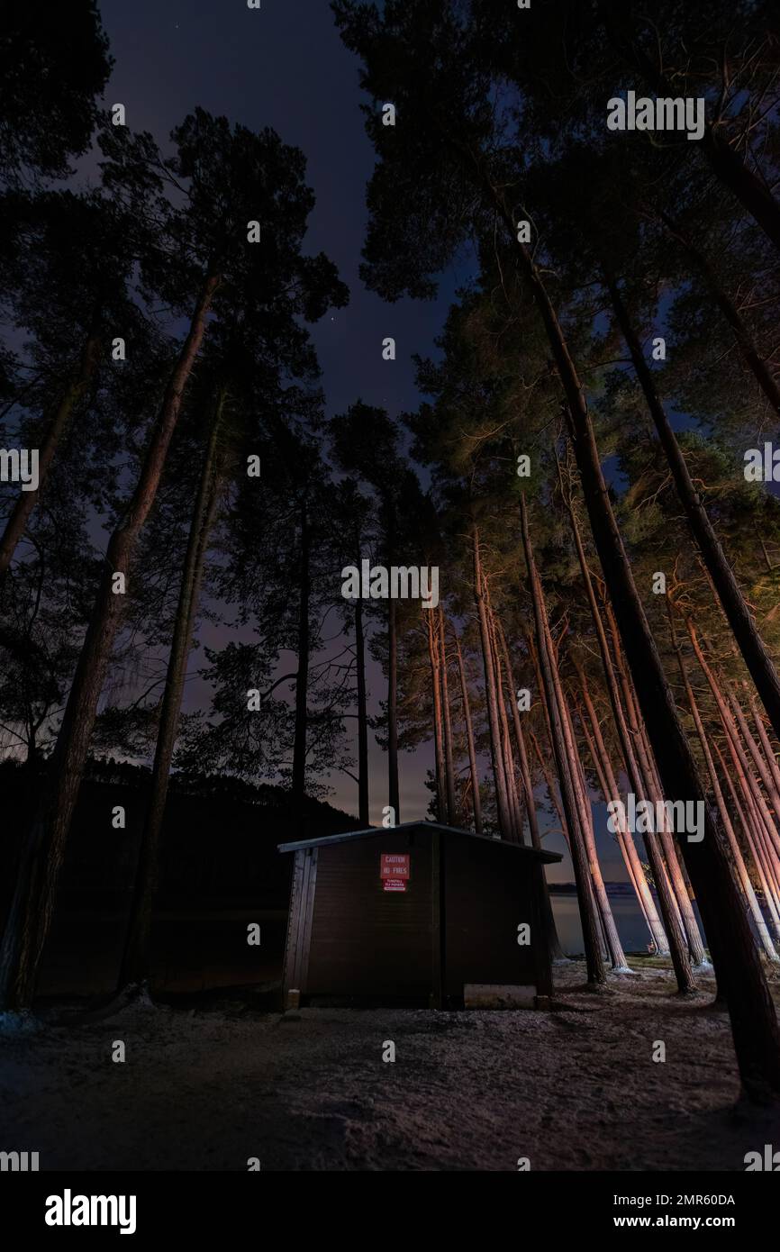 Wooden Fishing Hut at Tunstall Reservoir at night with snow on the ...