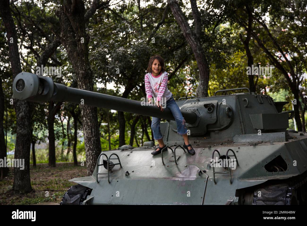 A girl poses for a pictures on a no longer being used military tank at ...