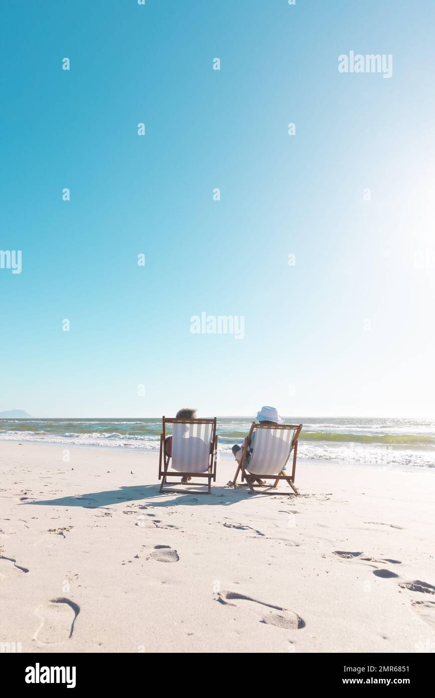African American Senior Couple Relaxing On Deckchairs In Front Of Sea