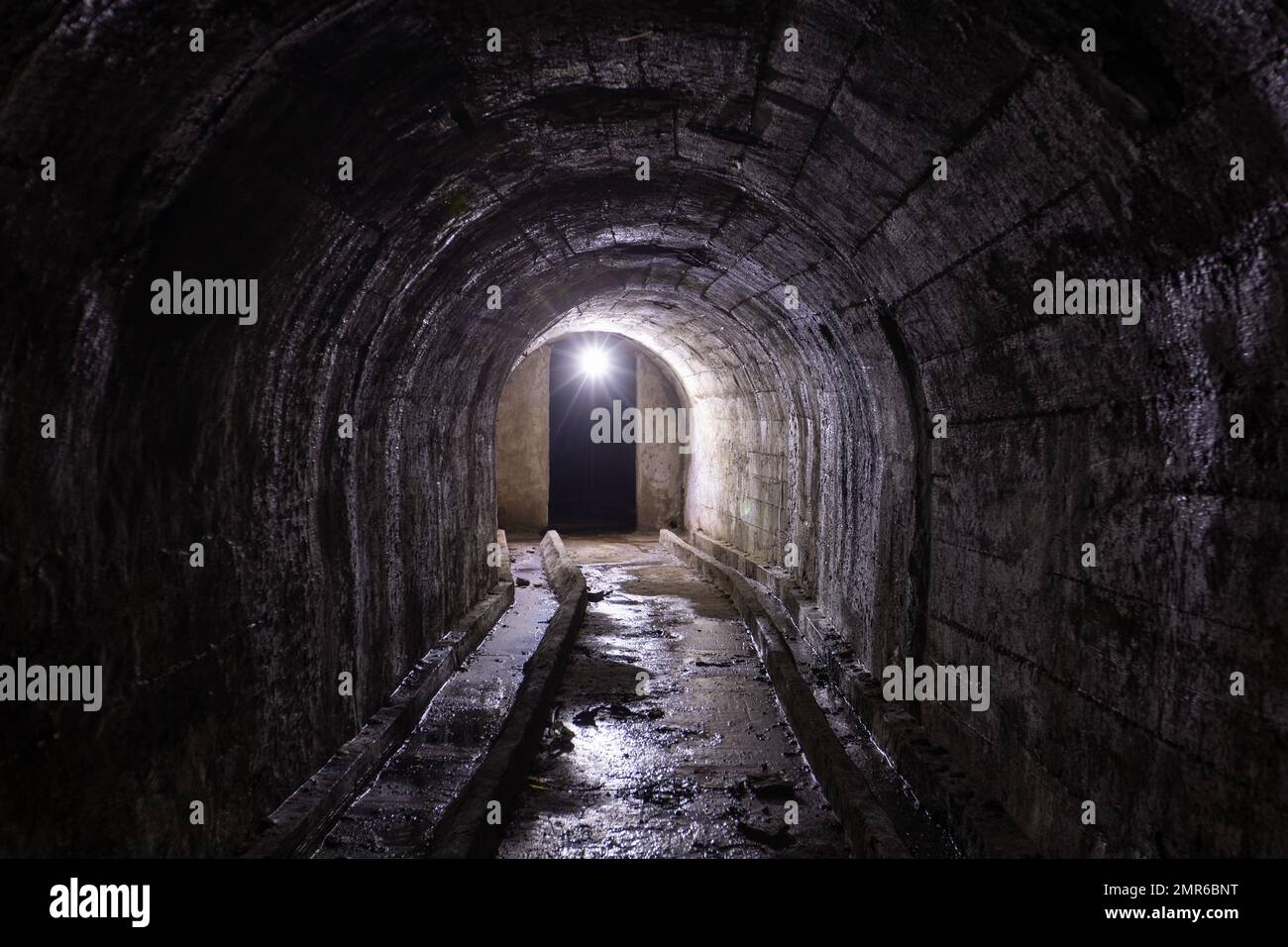 Vaulted tunnel with concrete walls in old abandoned bunker, mine ...