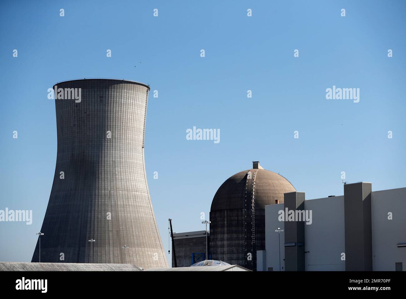 The reactor containment building at right and cooling tower at left are ...