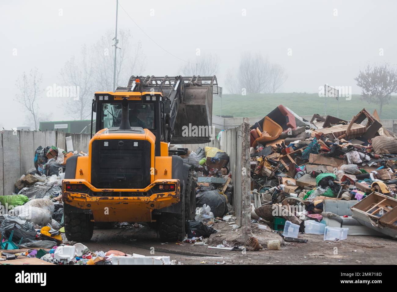 Front loader with scrap handling grapple bucket moving forward and ...