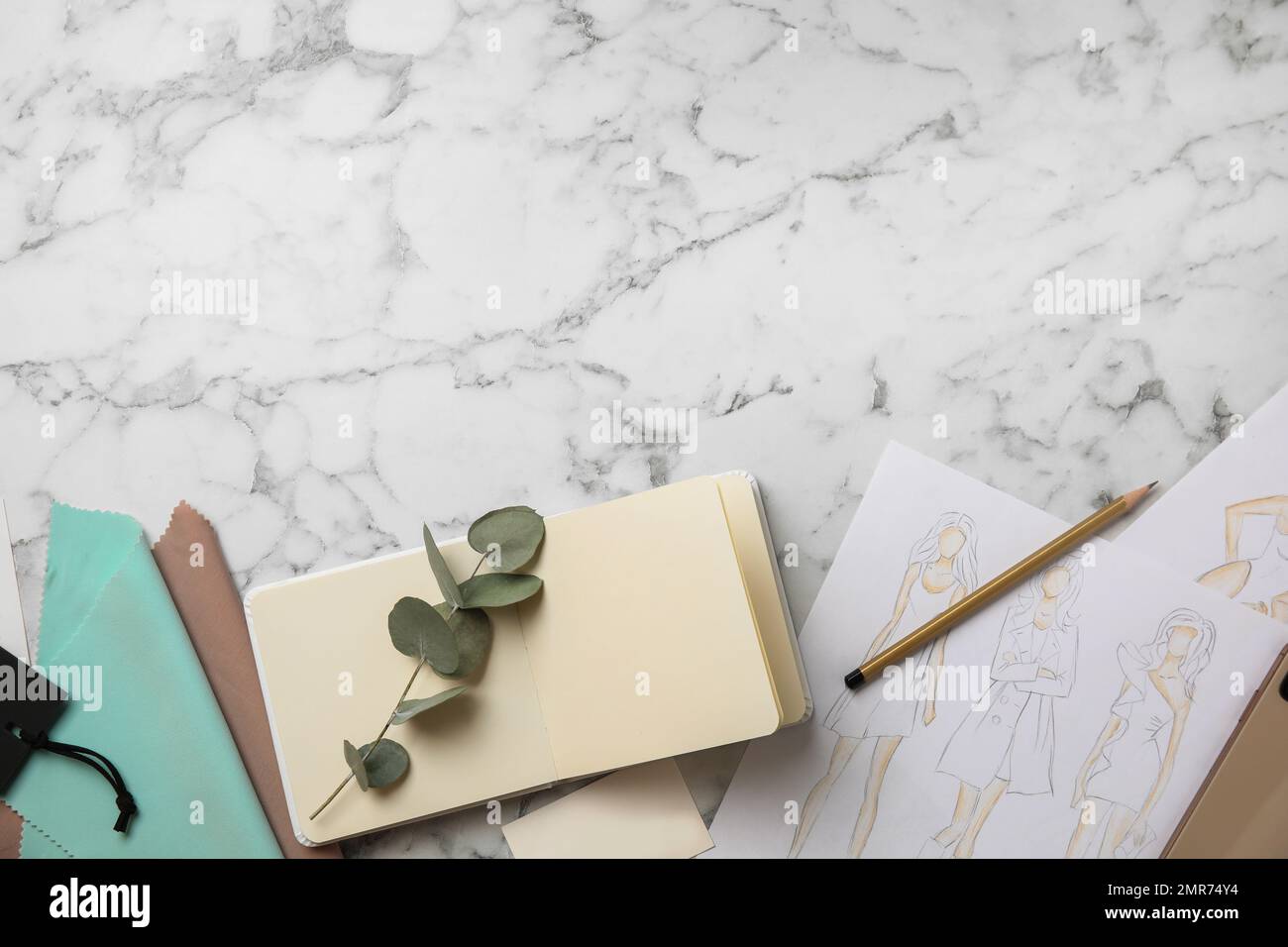 Flat lay composition with sketches and notebook on white marble table ...