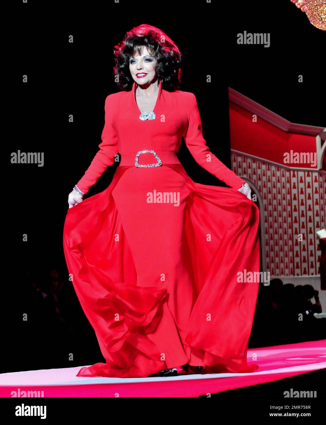 Joan Collins models a red dress at the annual Heart Truth Fashion Show ...
