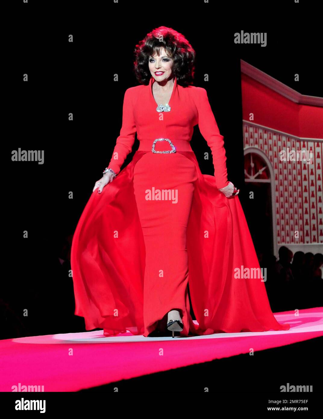 Joan Collins models a red dress at the annual Heart Truth Fashion Show ...
