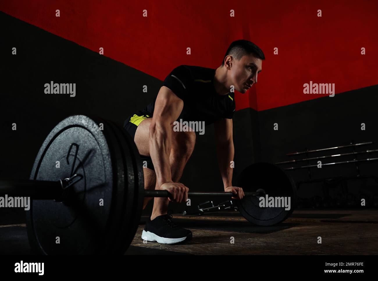 Strong man lifting barbell in modern gym Stock Photo - Alamy