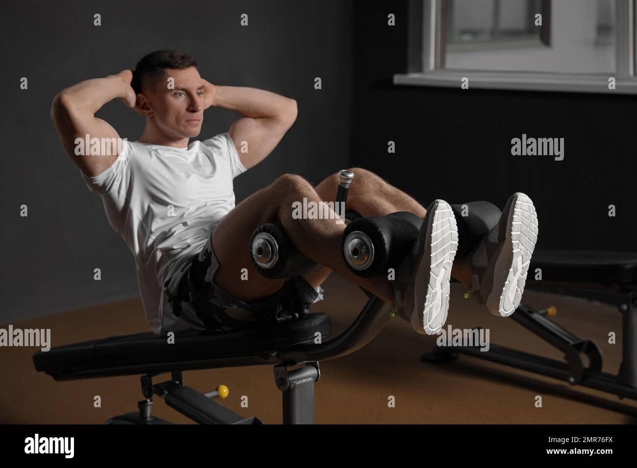 Man working out on adjustable sit up bench in modern gym Stock Photo ...