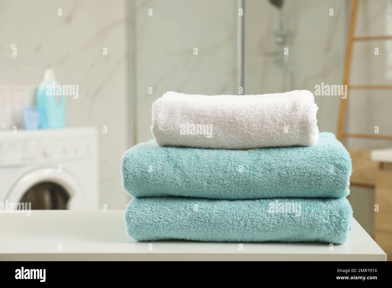 Stack of clean towels on table in laundry room Stock Photo - Alamy