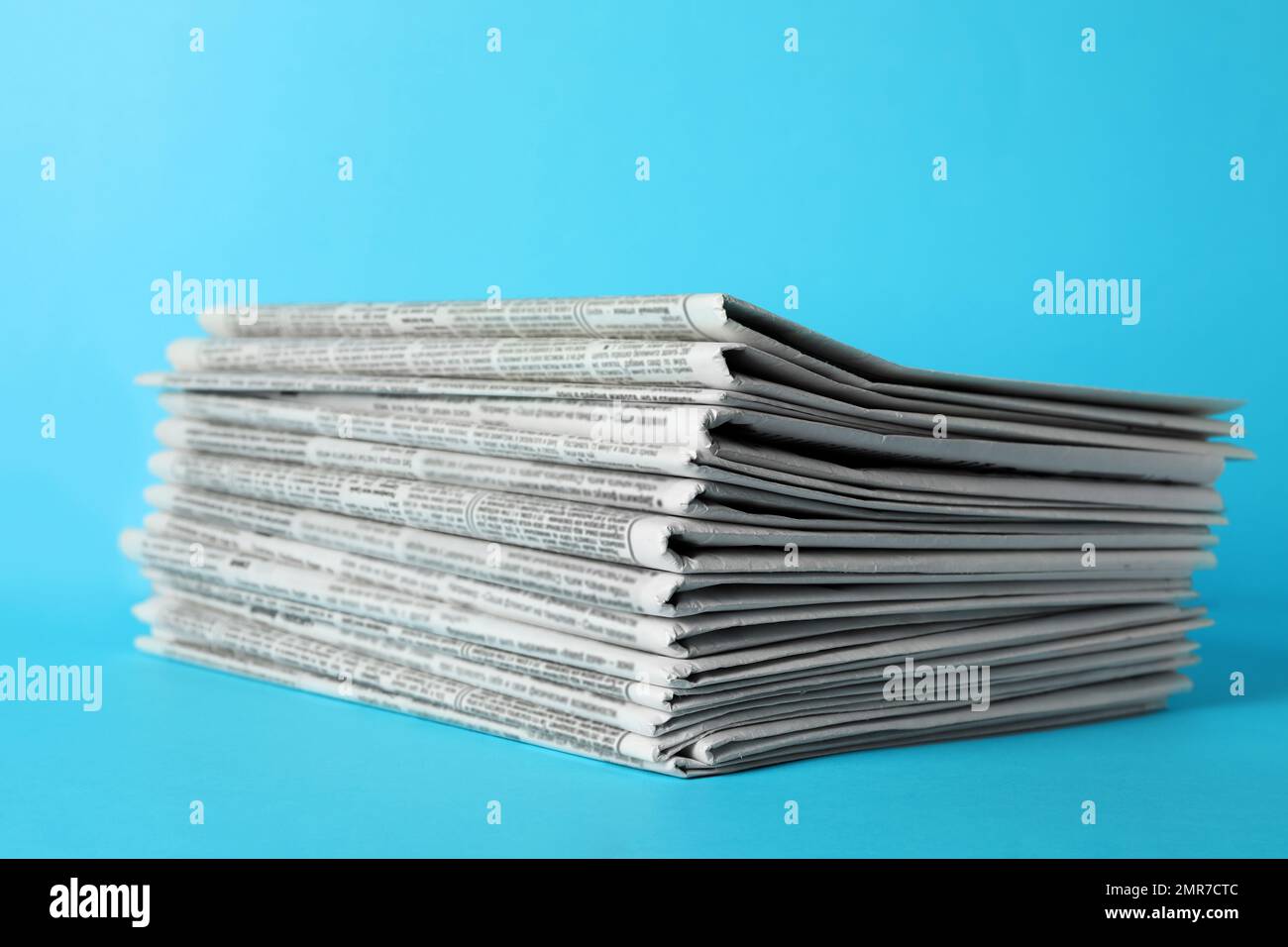 Stack of newspapers on light blue background. Journalist's work Stock ...