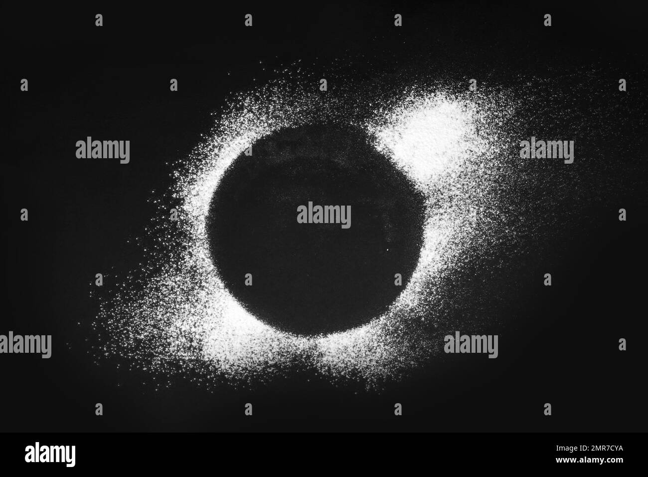 Round frame made of flour on black table, top view. Space for text ...