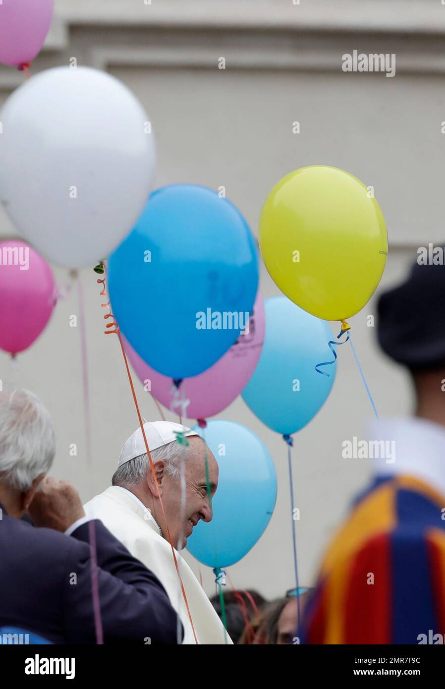 Pope Francis is framed by colored balloons as he greets blind faithful ...