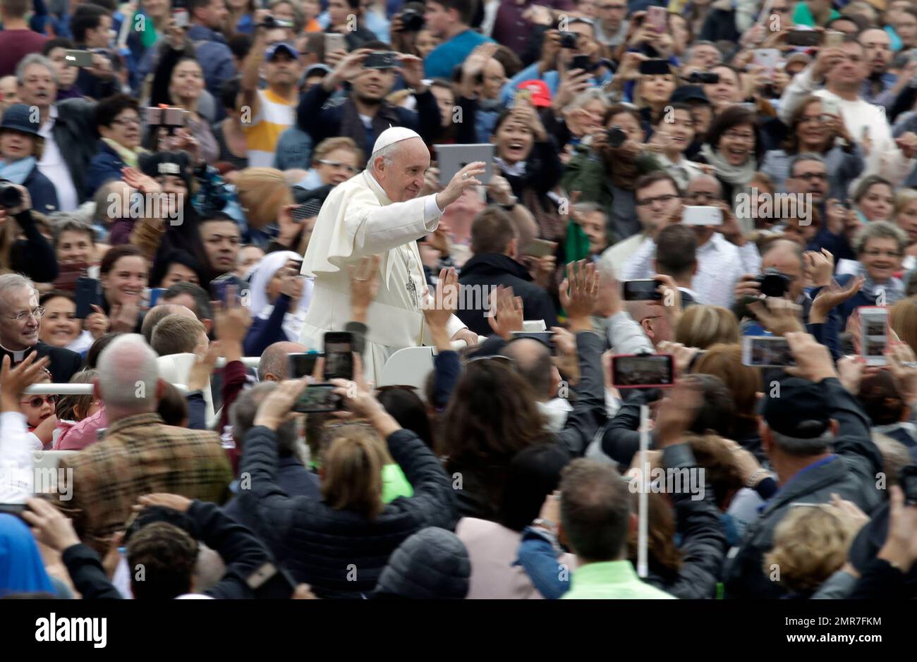 Pope Francis waves as he is driven by the crowd attending his weekly ...