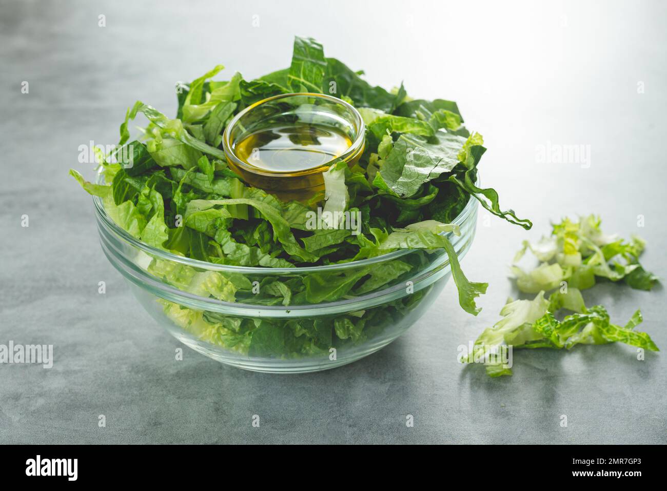 Cut fresh romaine lettuce close-up in a glass bowl and on a cutting ...