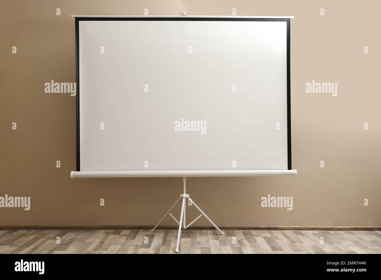 Blank projection screen near beige wall indoors. Space for design Stock ...