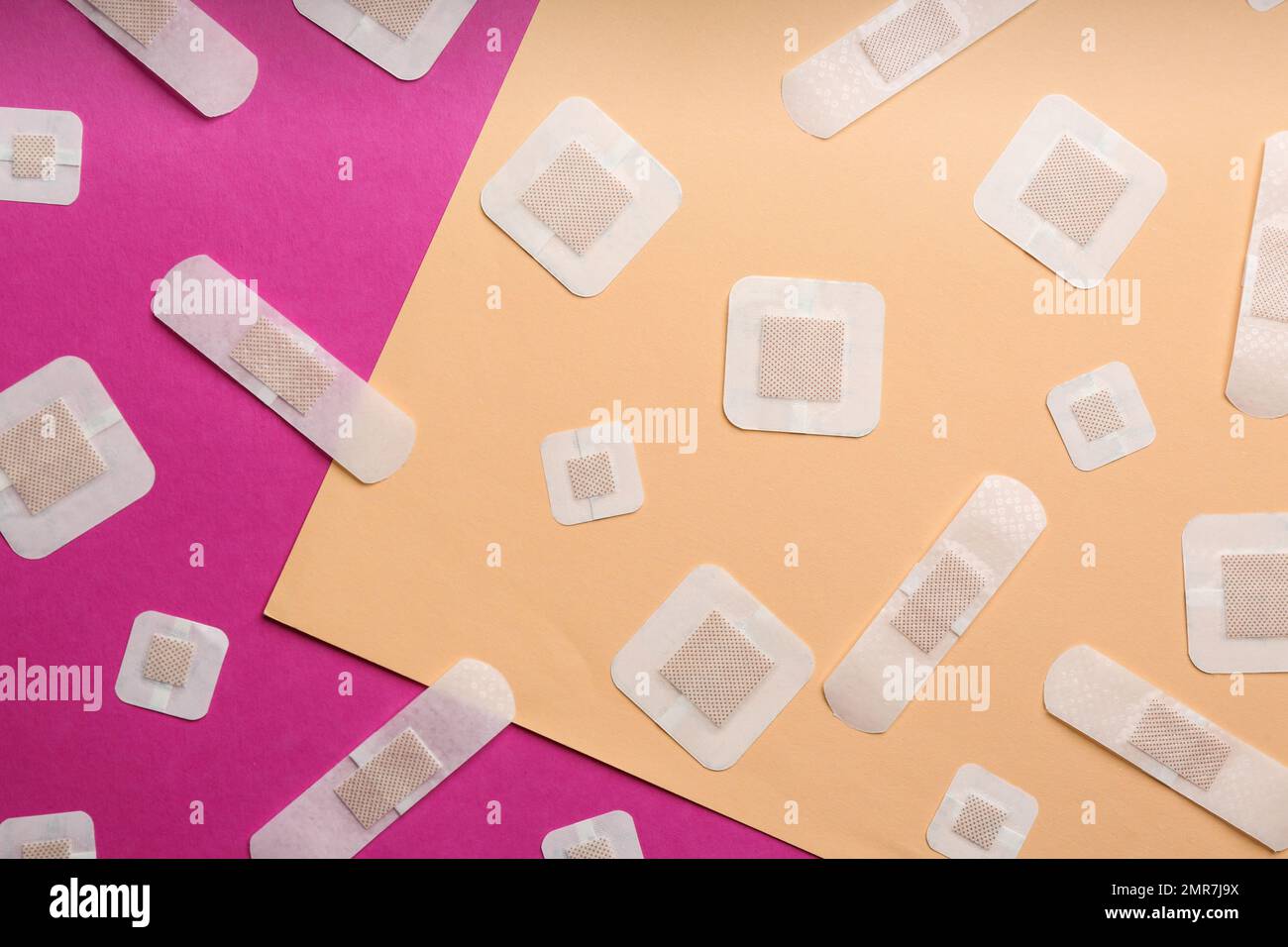 Different types of sticking plasters on color background, flat lay ...