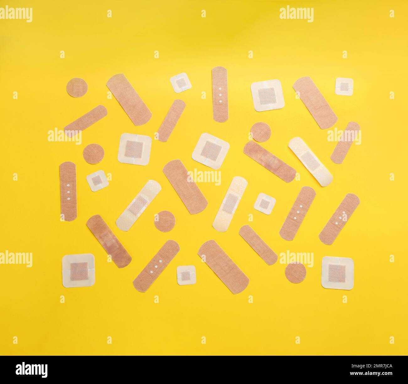 Different types of sticking plasters on yellow background, flat lay ...