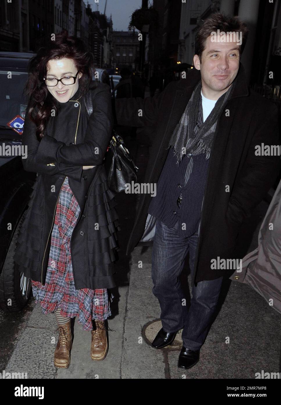 Actress Helena Bonham Carter tries to keep warm as she strolls with a ...