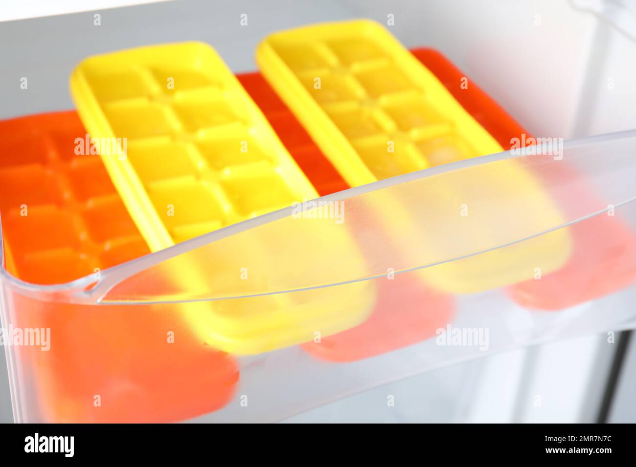 Different plastic ice cube trays in fridge Stock Photo - Alamy