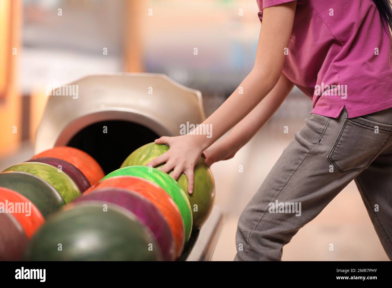 Little girl taking ball in bowling club, closeup Stock Photo - Alamy