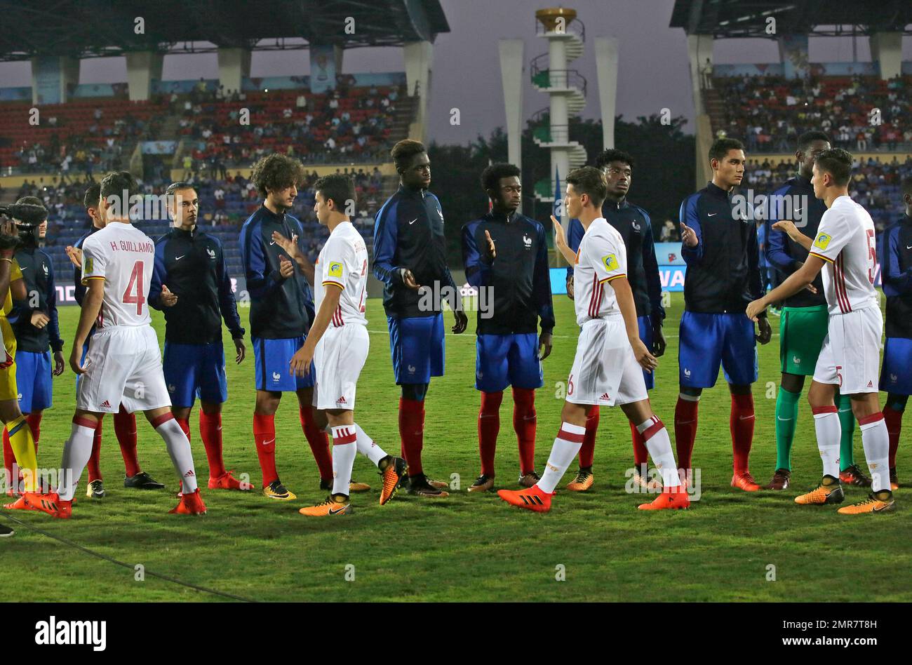 Spain's soccer players, in white, shake hands with team France players ...