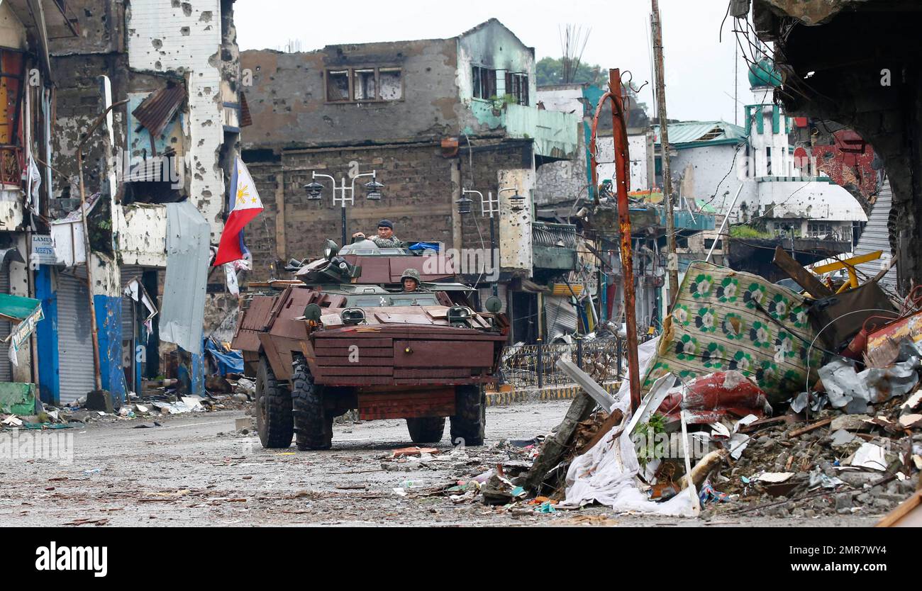 Philippine troops maneuver through a battle zone in their armored ...