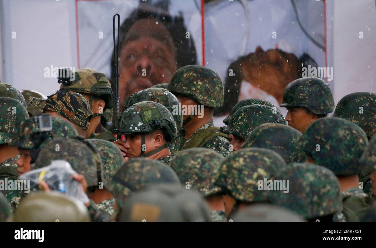 In front of a tarpaulin poster showing the faces of killed Muslim ...