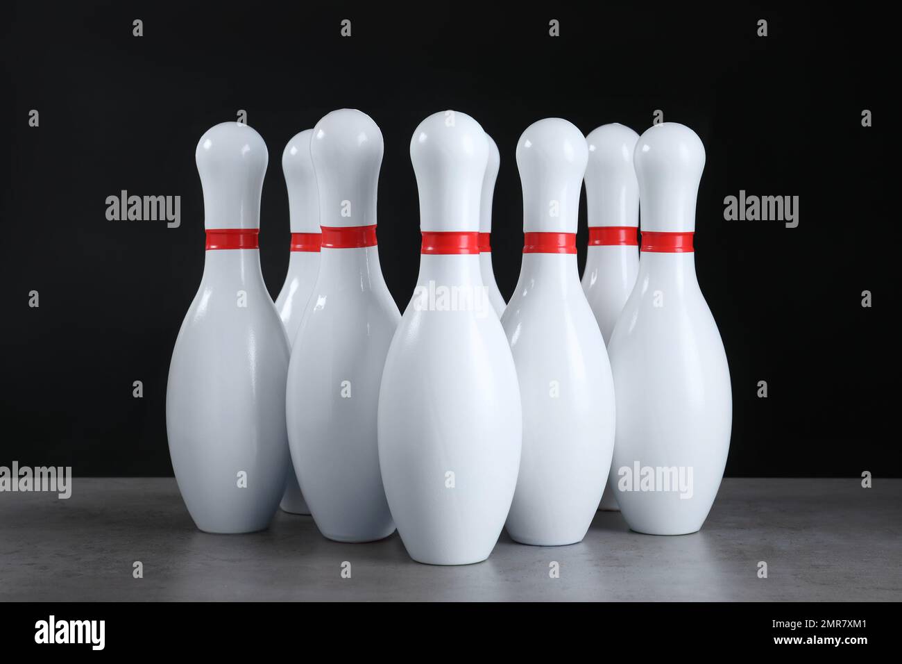 Set of bowling pins on grey stone table Stock Photo - Alamy