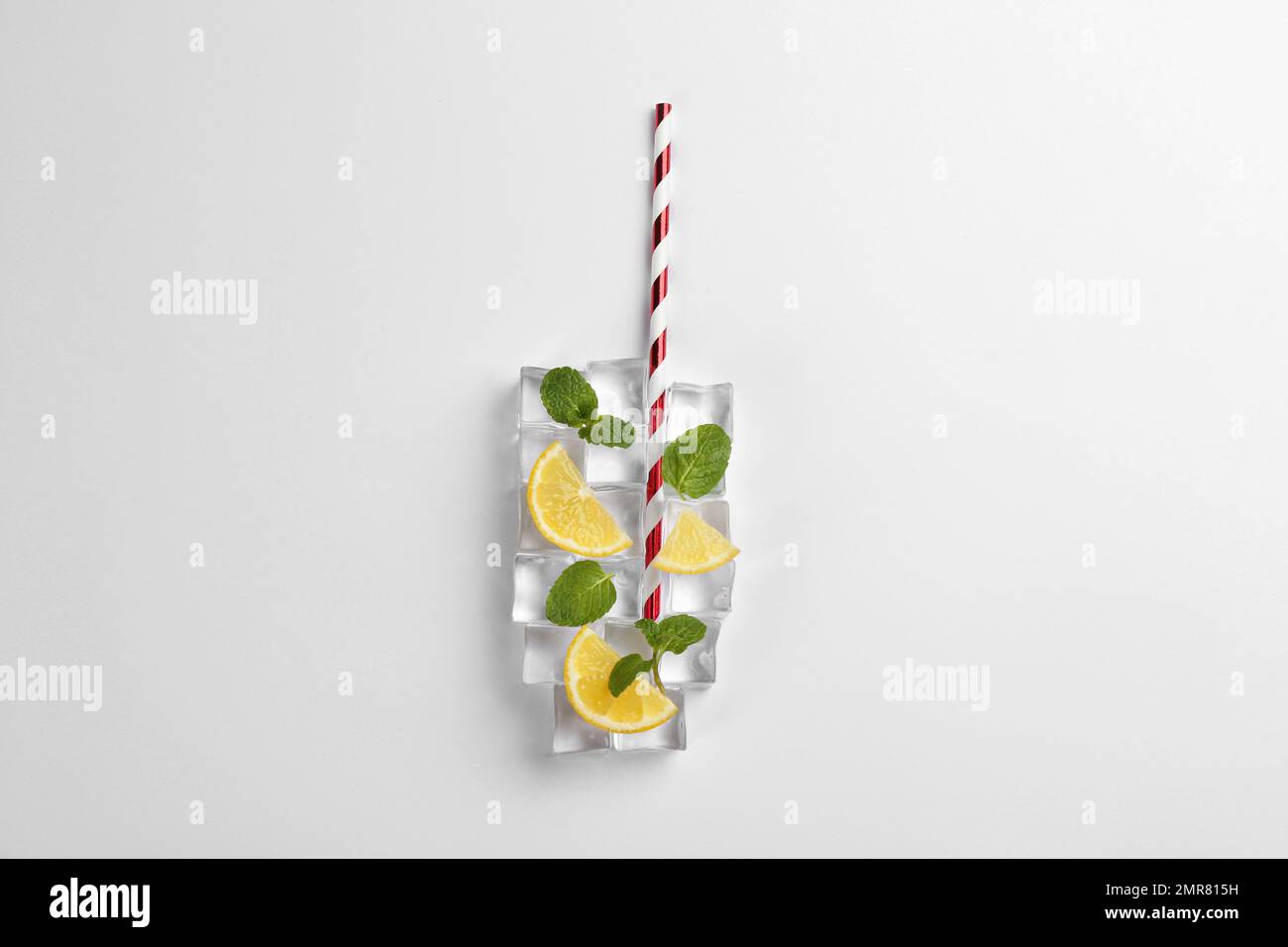 Creative lemonade layout with lemon slices, straw, ice cubes and mint on white background, top ...