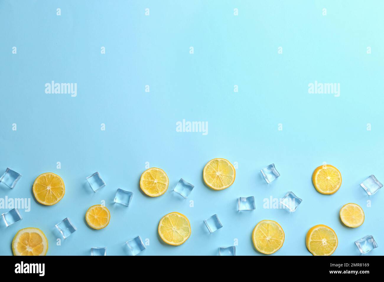 Lemonade layout with juicy lemon slices and ice cubes on light blue ...