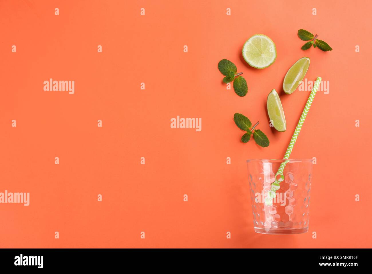 Creative lemonade layout with lime slices and mint on coral background ...