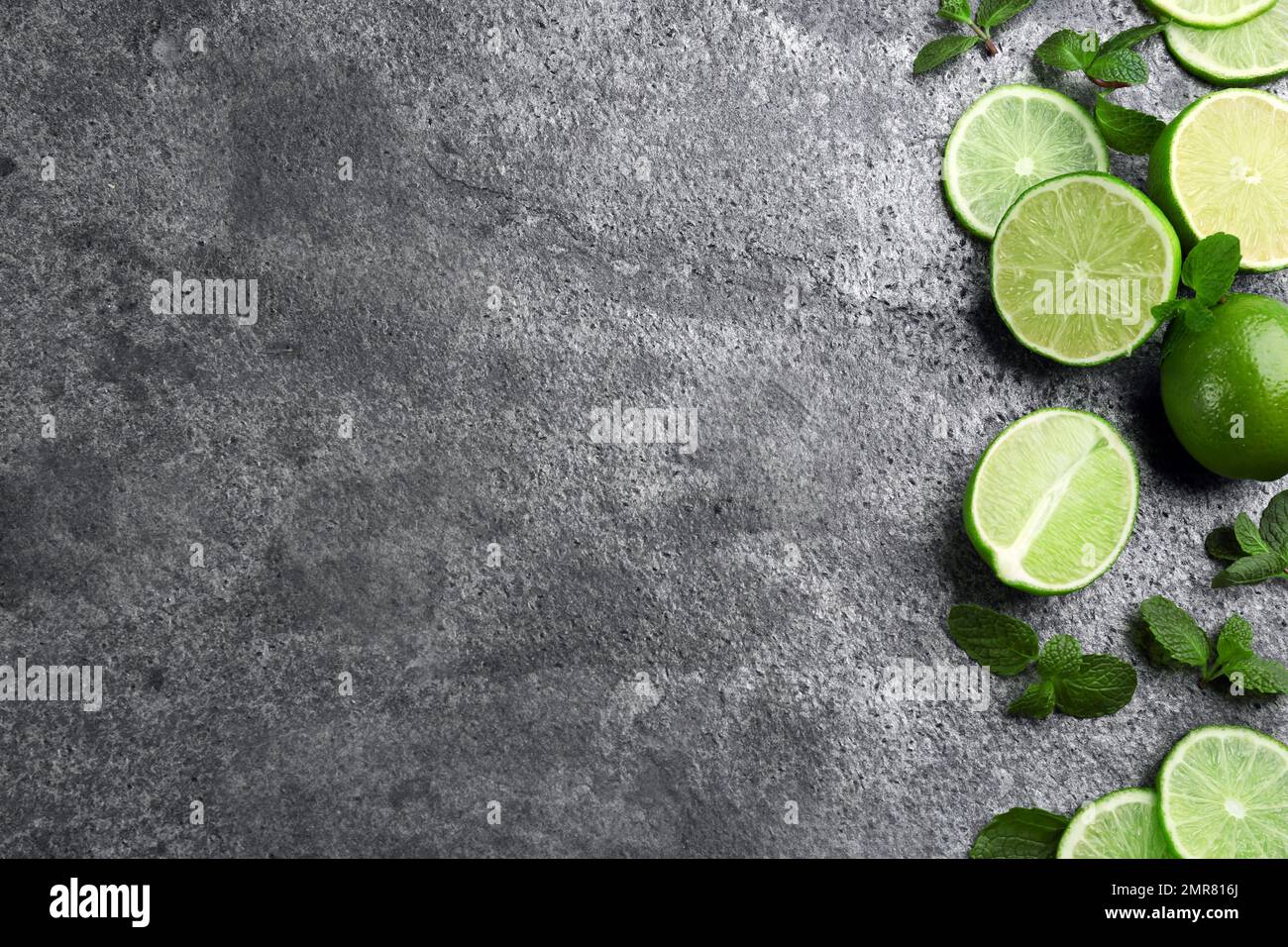 Lemonade layout with juicy lime slices and mint on grey table, top view ...