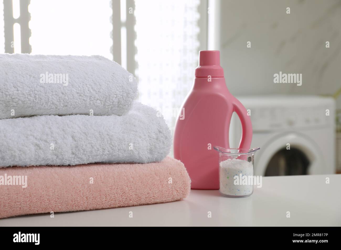 Clean towels and detergents on table in laundry room Stock Photo - Alamy