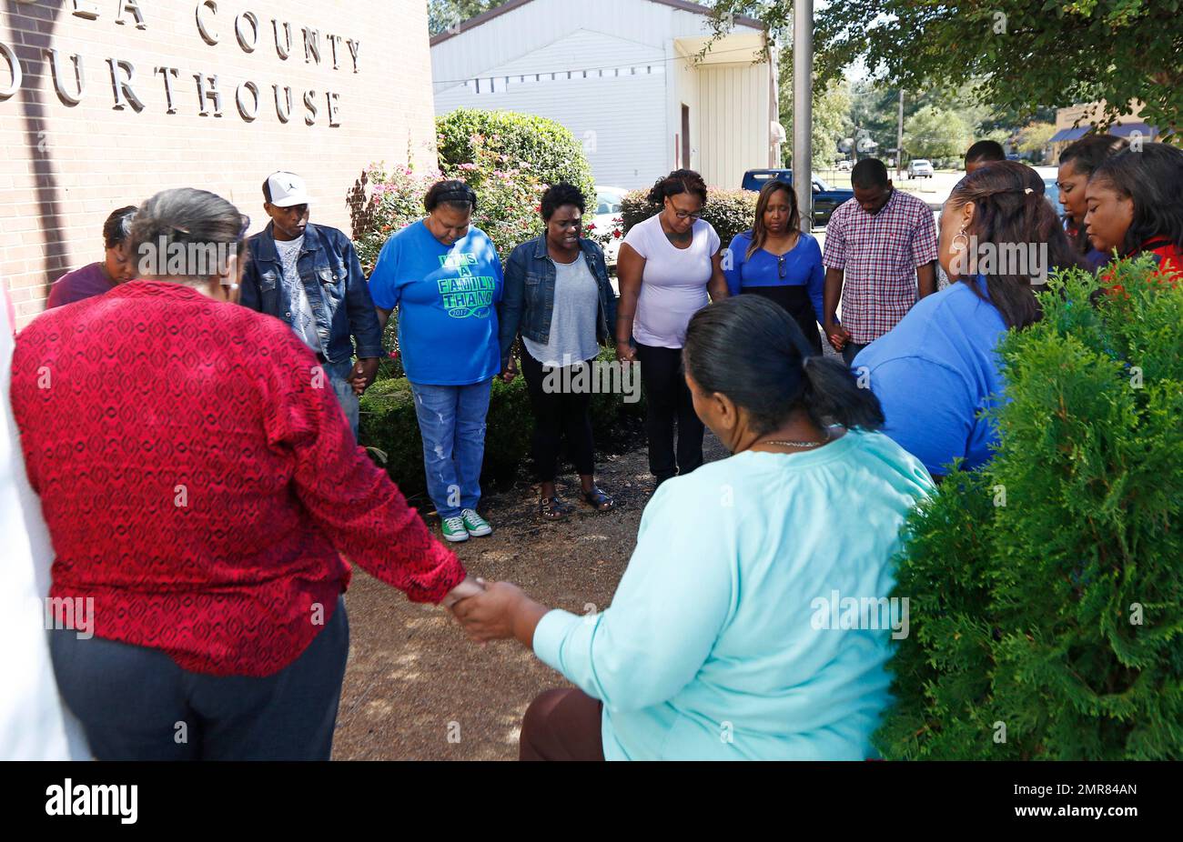 Family members and friends of Quinton Tellis, pray on the steps of the ...