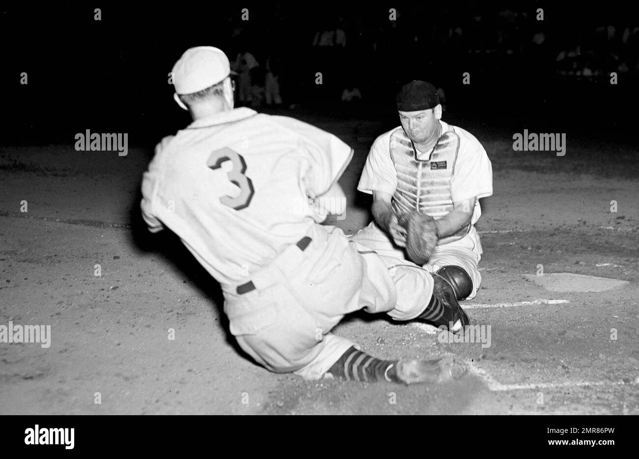 Babe Dahlgren, left, St. Louis Browns first baseman, takes a slide but ...