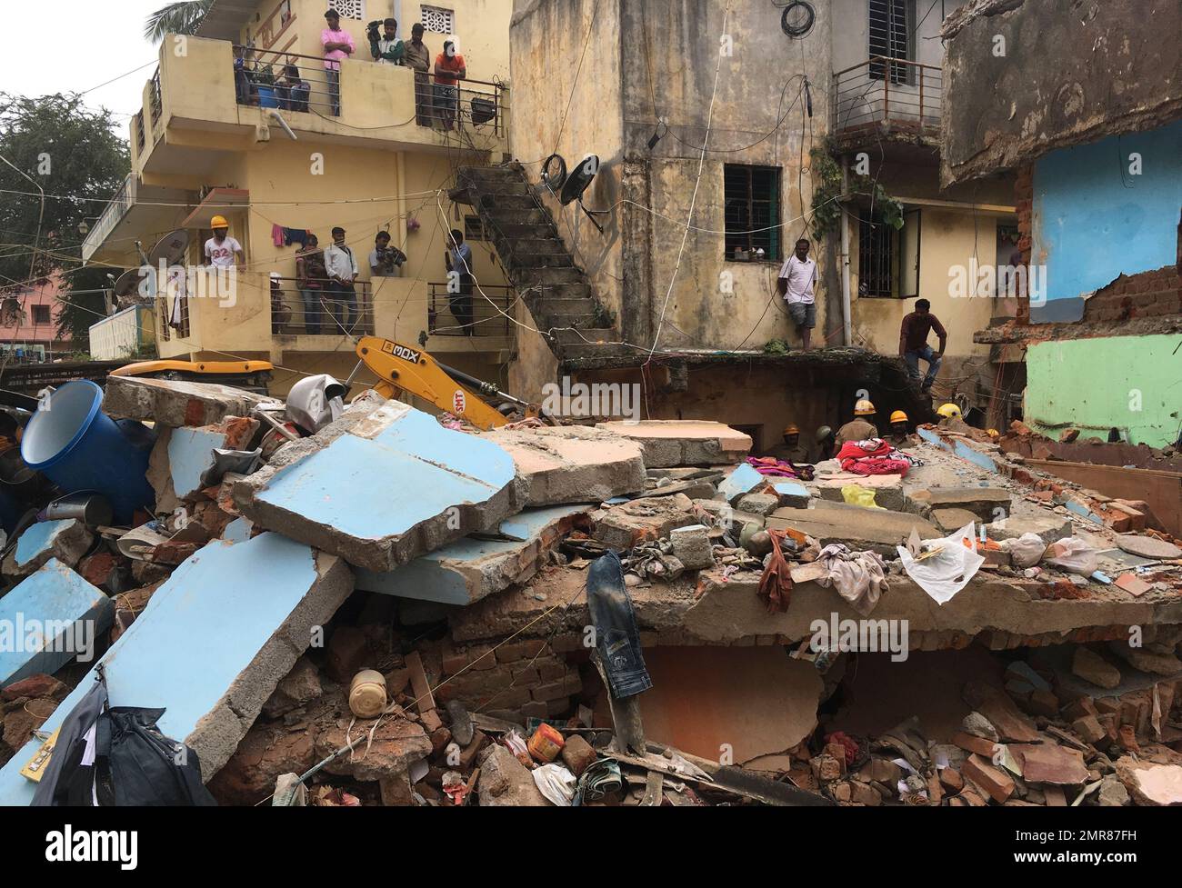 Rescuers work at the site of a building collapse in Ejipura area ...