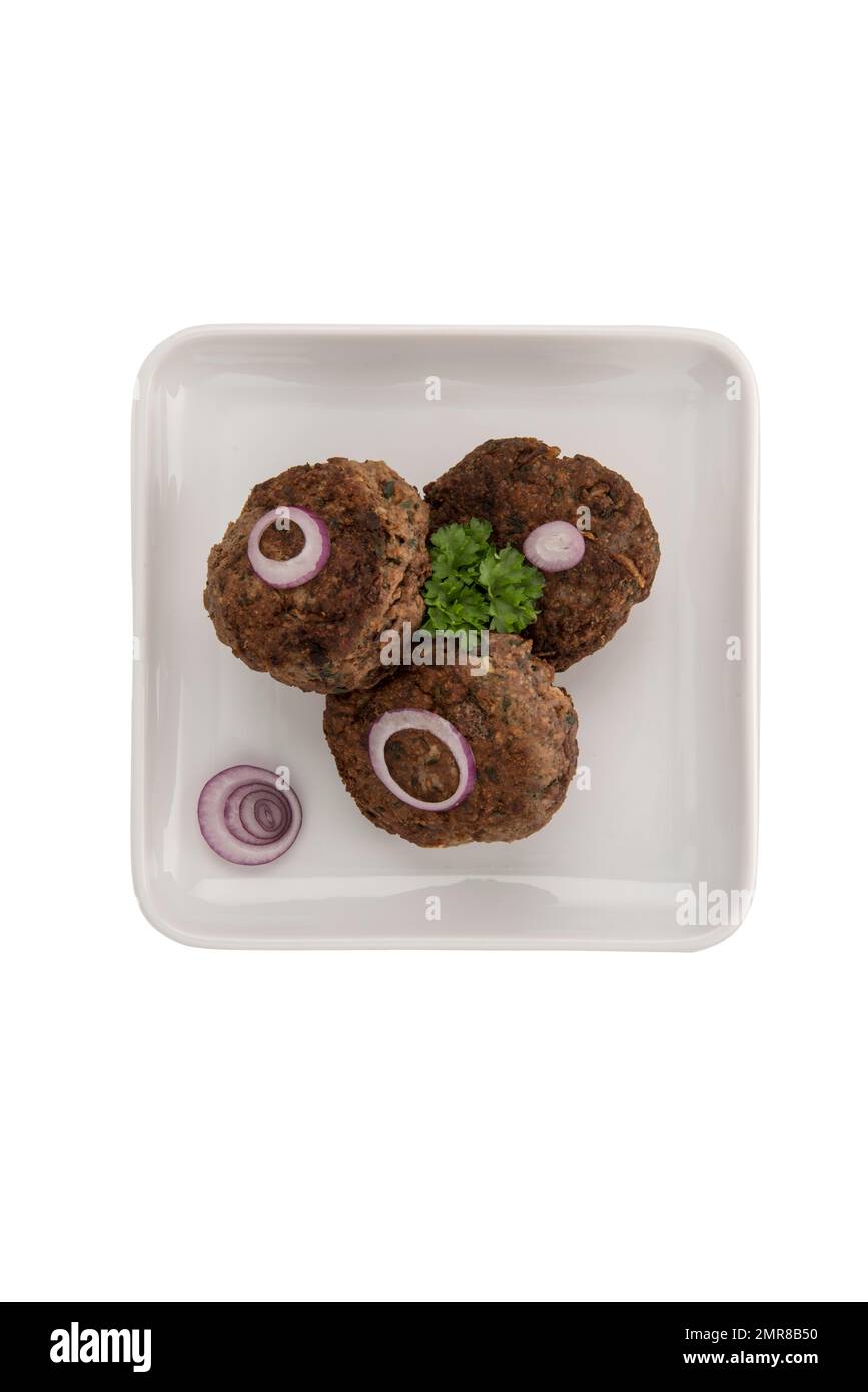 Three meatballs on a plate, cropped, studio shot against a white ...