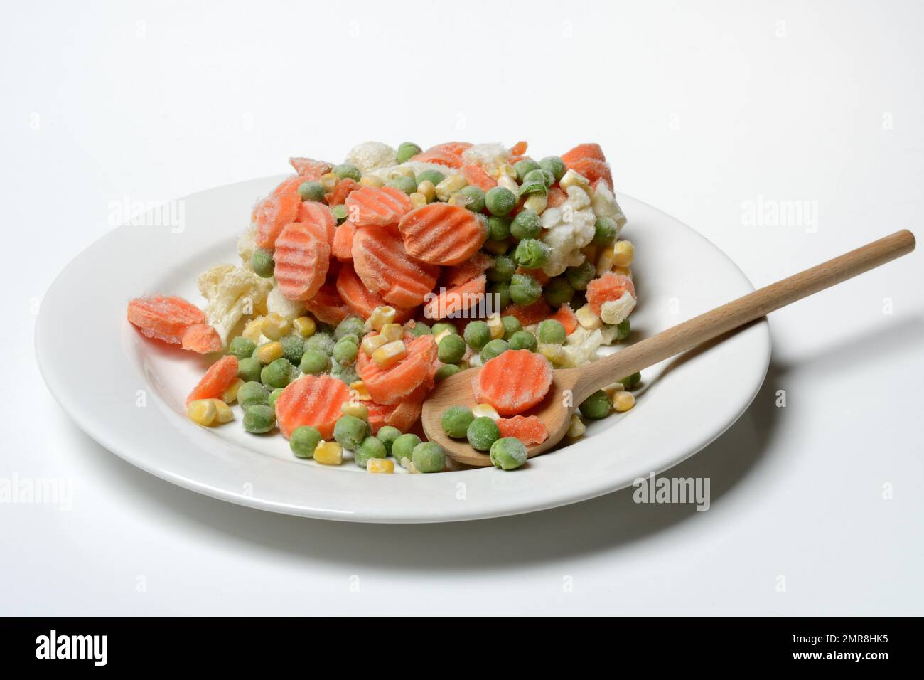 Frozen vegetables on plate with cooking spoon, frozen food Stock Photo ...